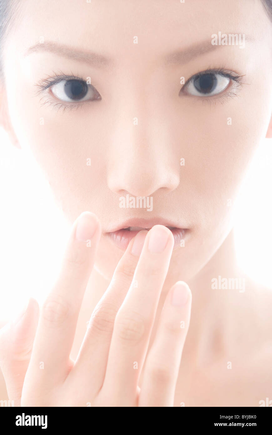 Young Woman with Fingers on Lips Stock Photo - Alamy