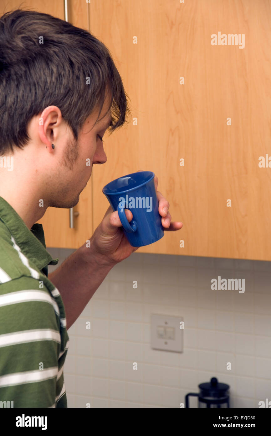 Young single man, 20s, in kitchen drinking coffee Stock Photo - Alamy