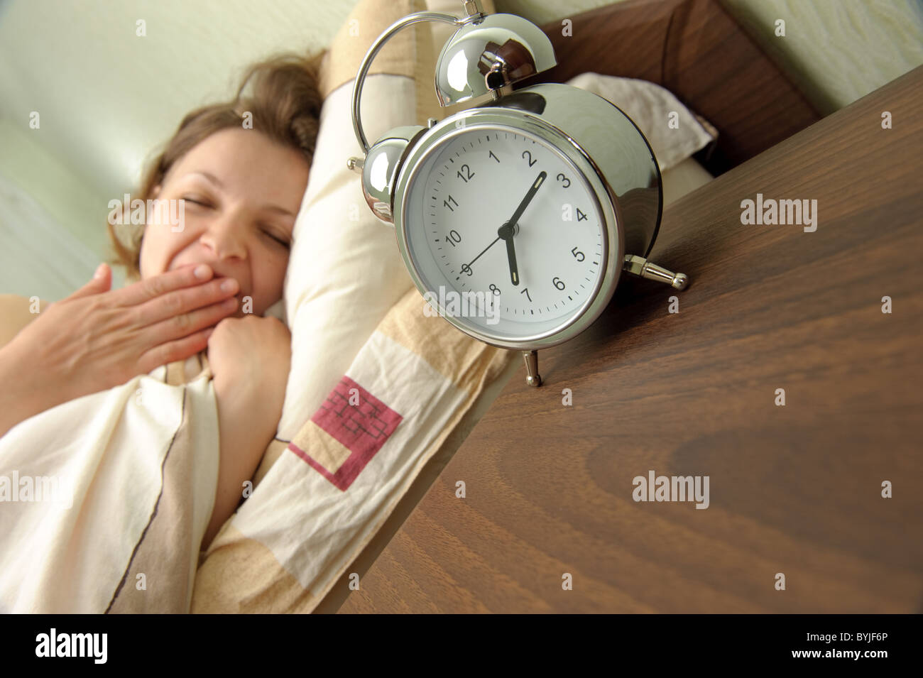 Young girl and alarm clock. Bedtime scene Stock Photo - Alamy