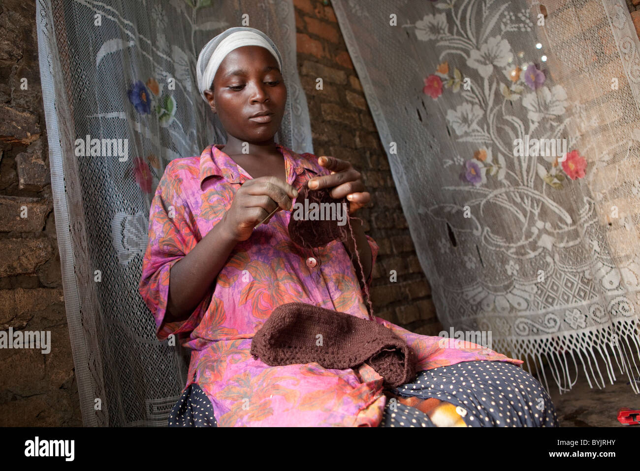 A woman knits clothes in rural Masaka, Uganda, East Africa Stock Photo ...