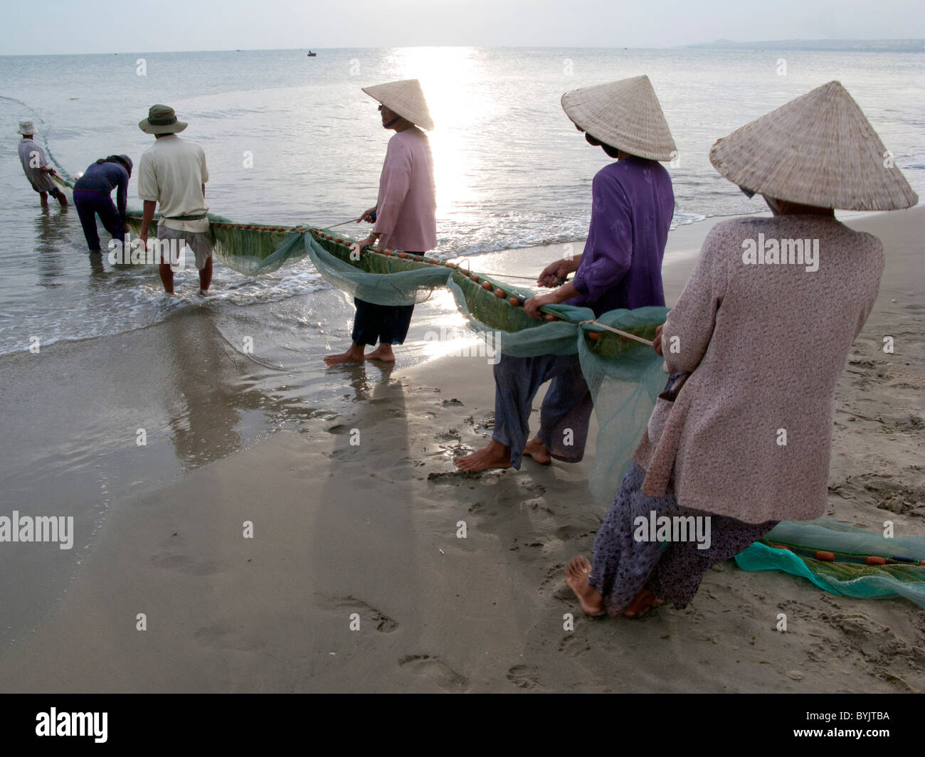 VIETNAM WOMEN FROM FISHING CO-OPERATIVE CASTING NET IN THE SEA NEAR MUI ...
