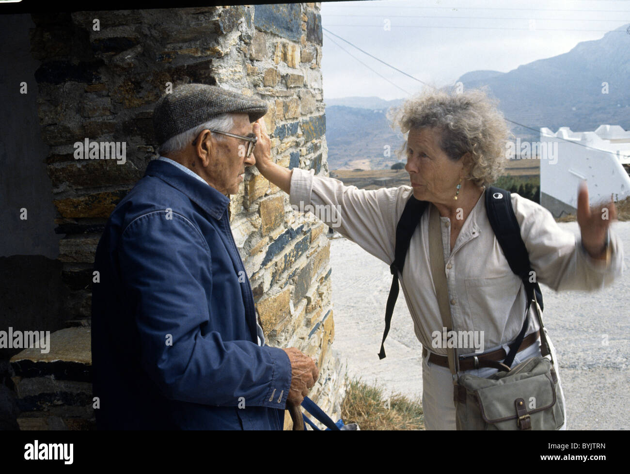 elderly English woman talking with a old Greek local man in Greece ...