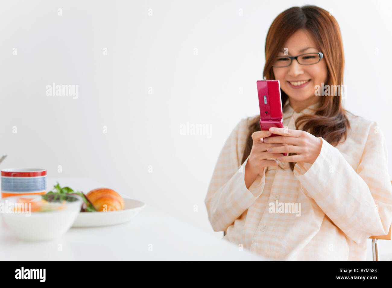 Young woman on table and using phone hi-res stock photography and ...