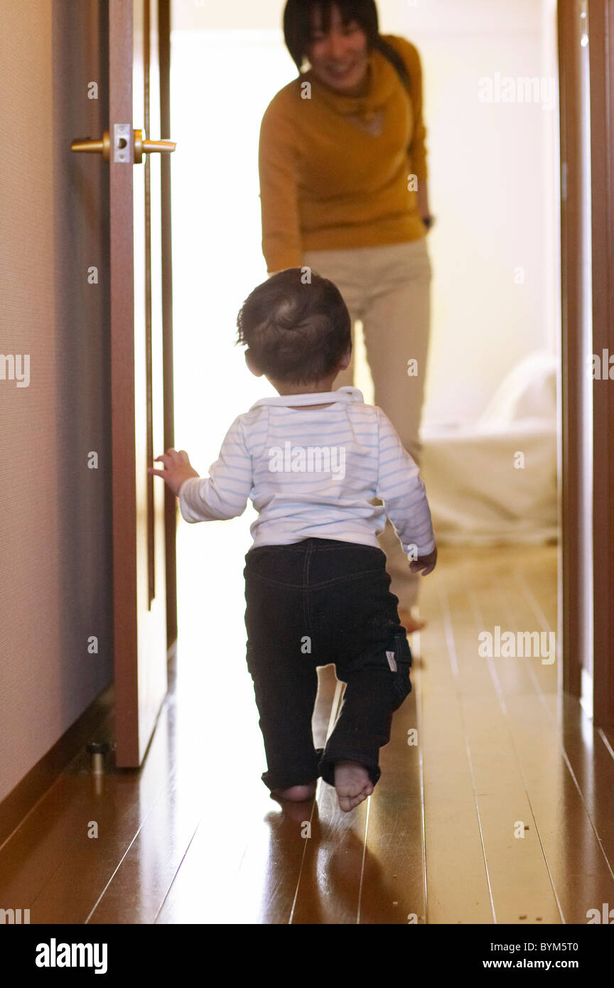 Rear View of Baby Girl Walking Towards Mother Stock Photo - Alamy