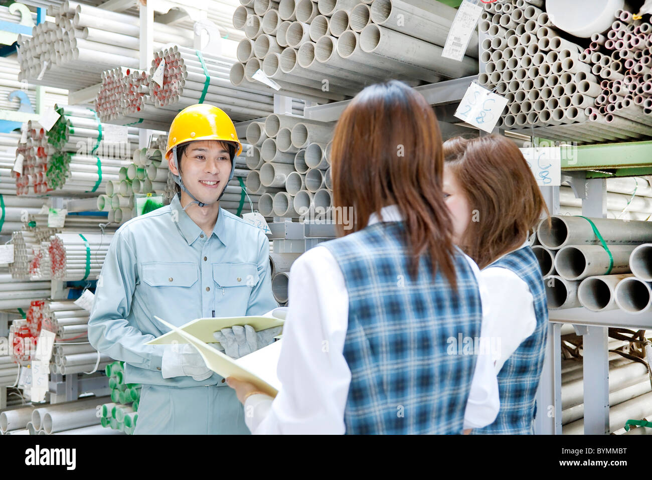Warehouse Worker Talking to Two Female Colleagues Stock Photo - Alamy