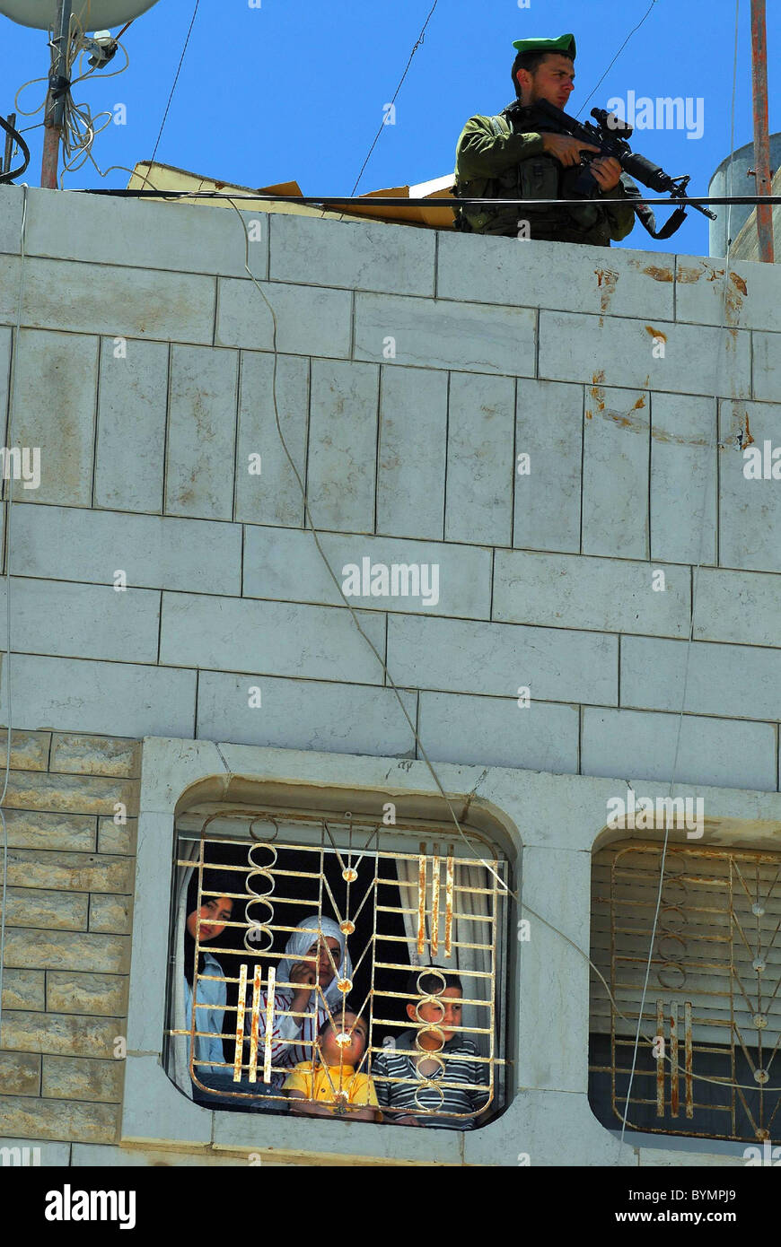 IDF soldier on guard on a Palestinian home's roof while the family ...