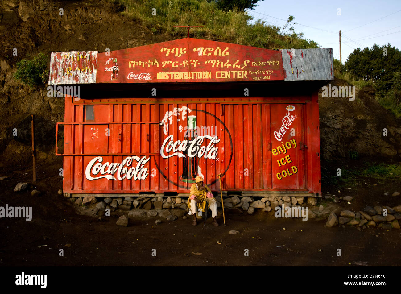 a priest sitting by a coca cola sign Stock Photo - Alamy
