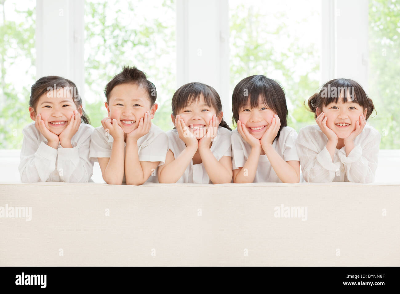 Kids Hand On Chin Sofa Looking At Camera Smiling Stock Photo - Alamy