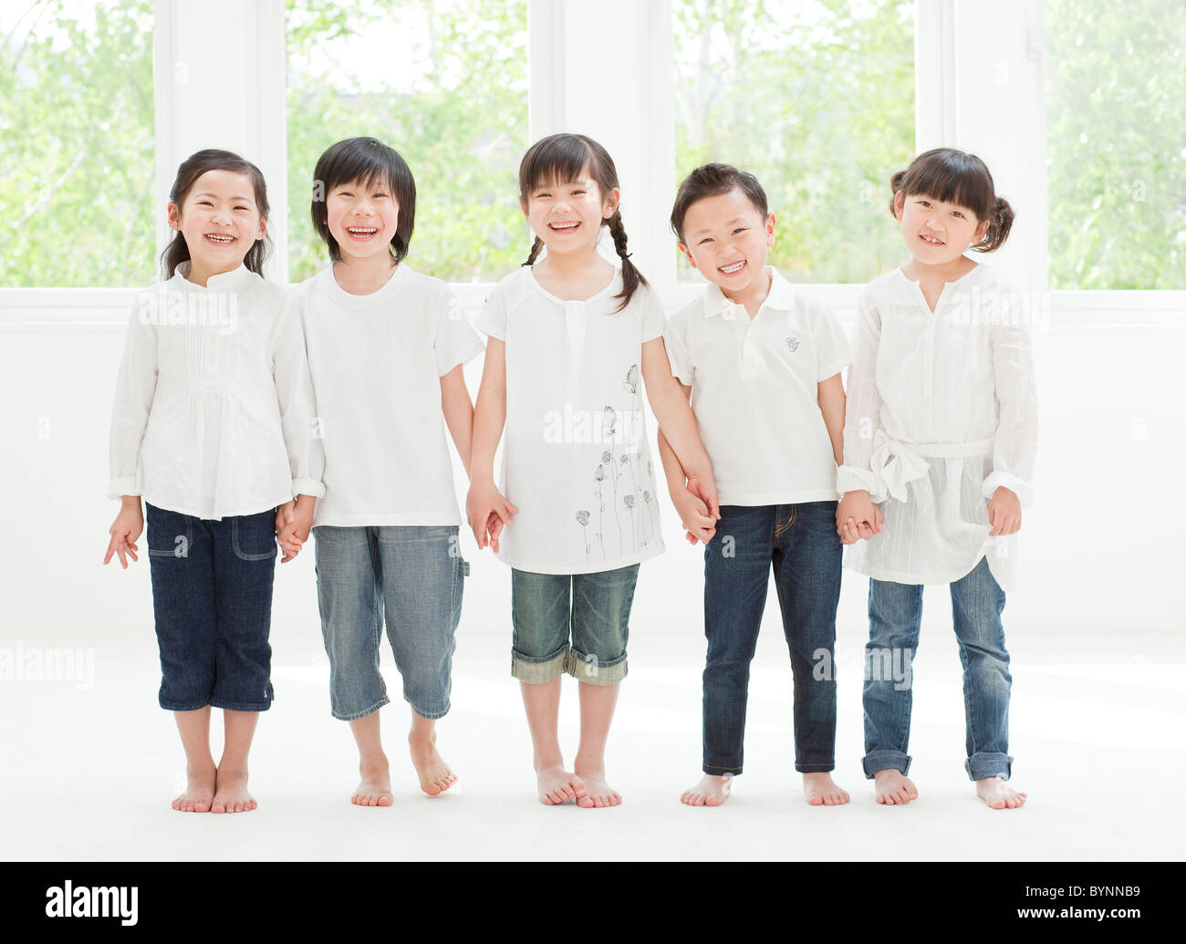 Kids Standing Holding Hands Looking At Camera Stock Photo - Alamy