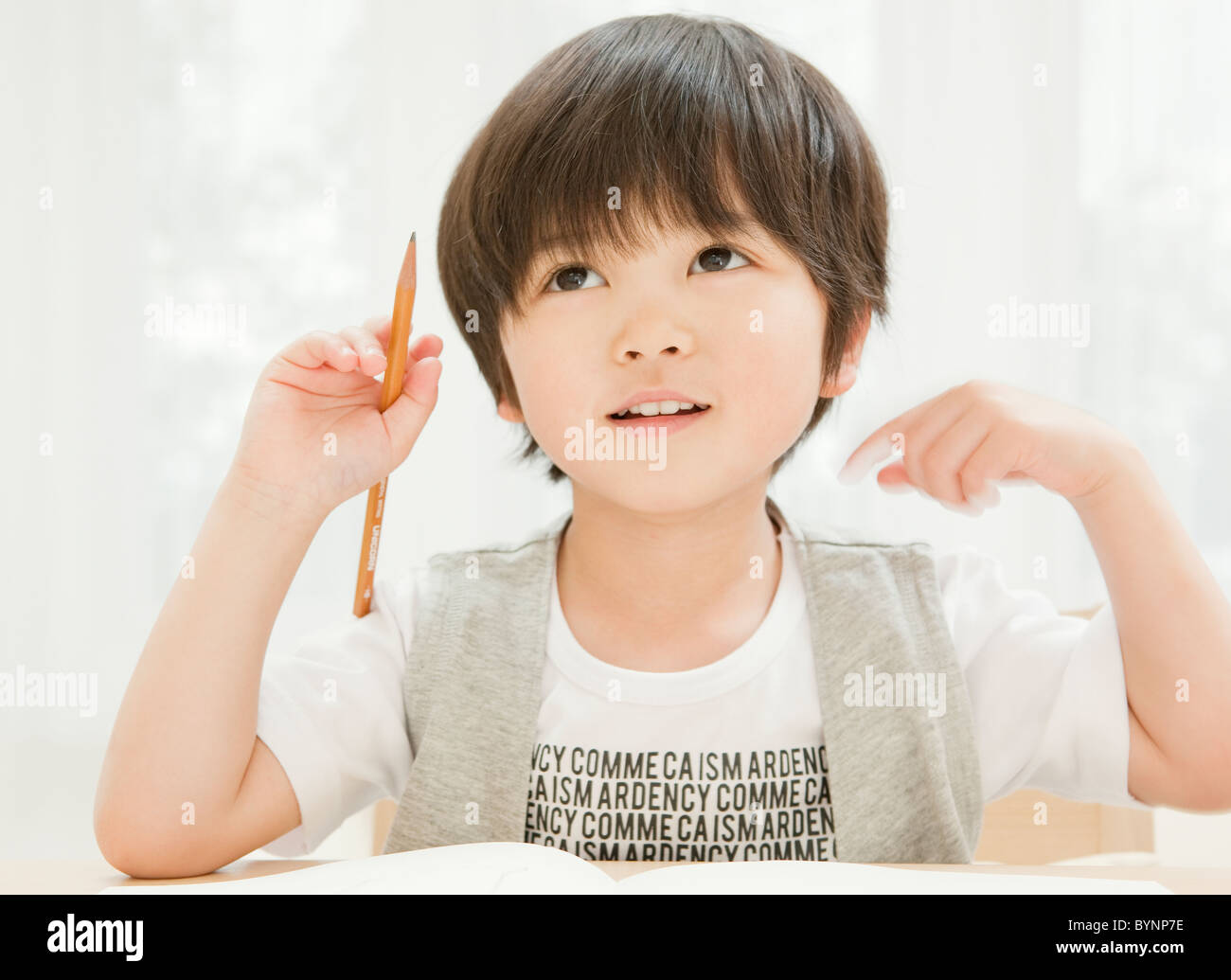 Boy Sitting Table Holding Pencil Thinking Stock Photo - Alamy