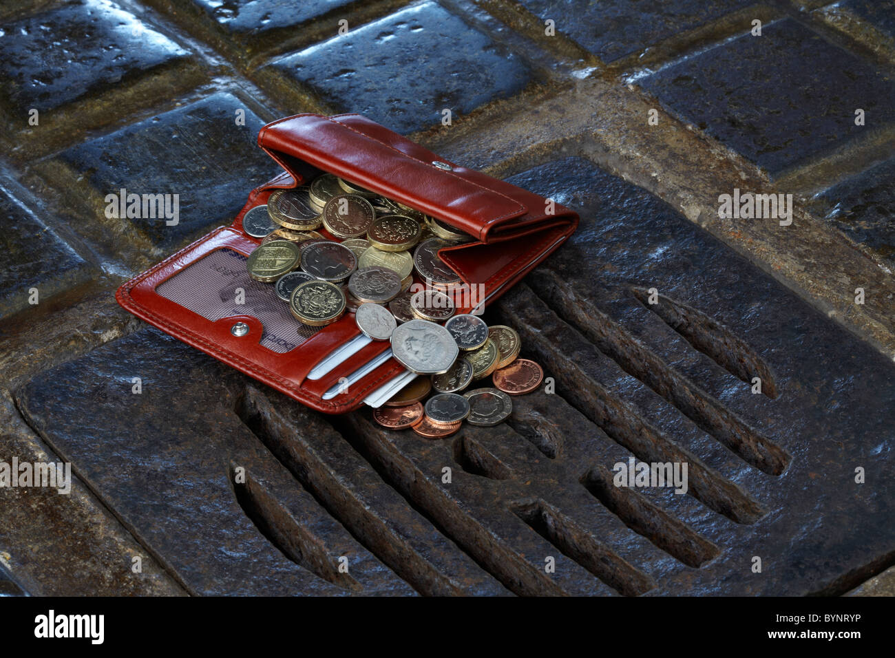 Purse of Money Falling down Drain Stock Photo - Alamy