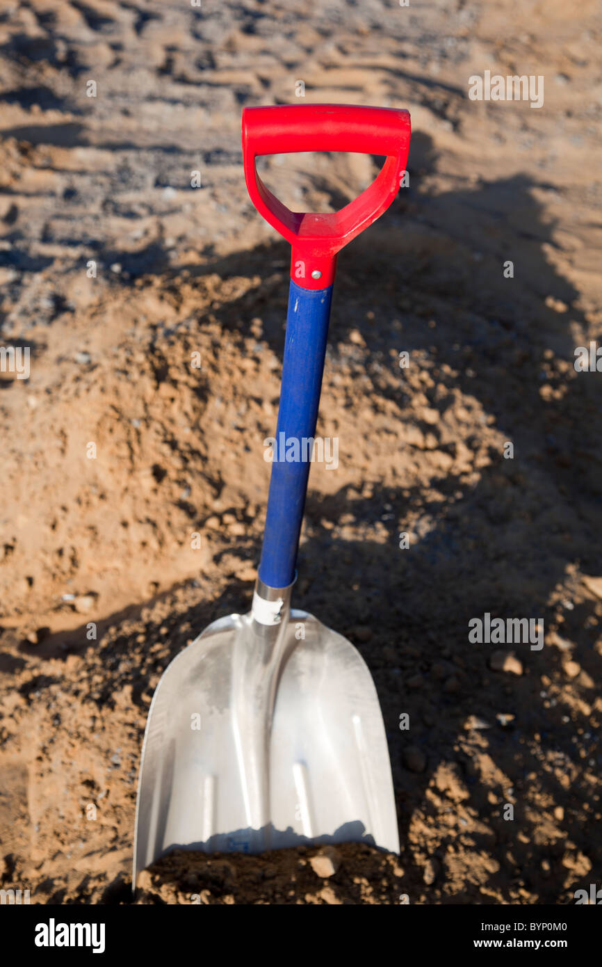 New spade stuck into sand Stock Photo - Alamy