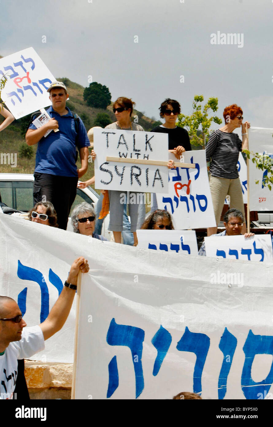 Israeli activists from the Peace Now movement brandish Hebrew posters ...