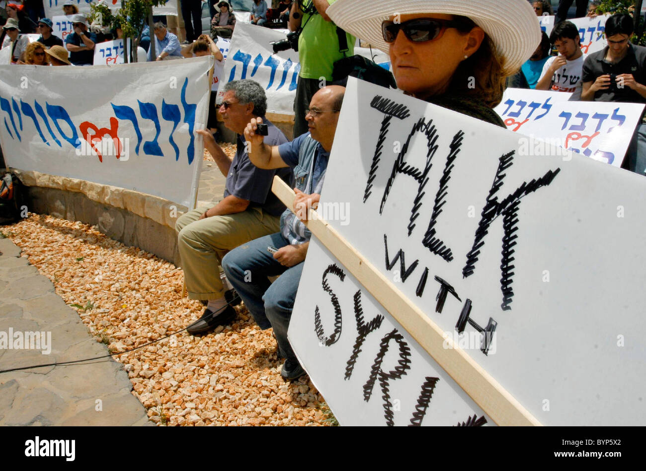 Israeli activists from the Peace Now movement brandish Hebrew posters ...