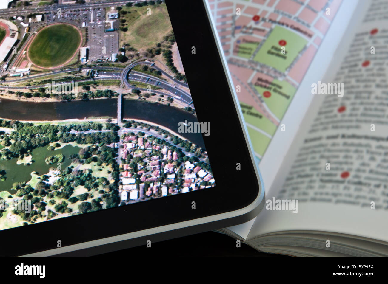 Modern Tablet PC displaying a city map with classic printed travel ...