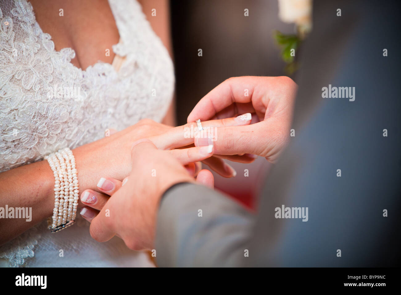 Bride and groom putting on the wedding ring on their wedding ceremony ...