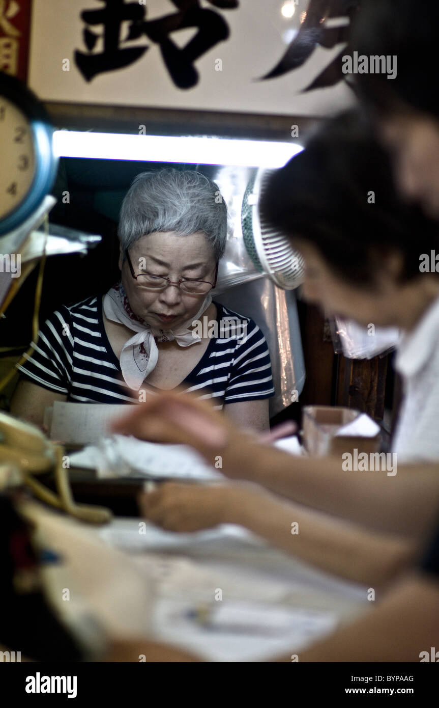 Japanese women accounting for sales at Tsukiji fish market Stock Photo ...
