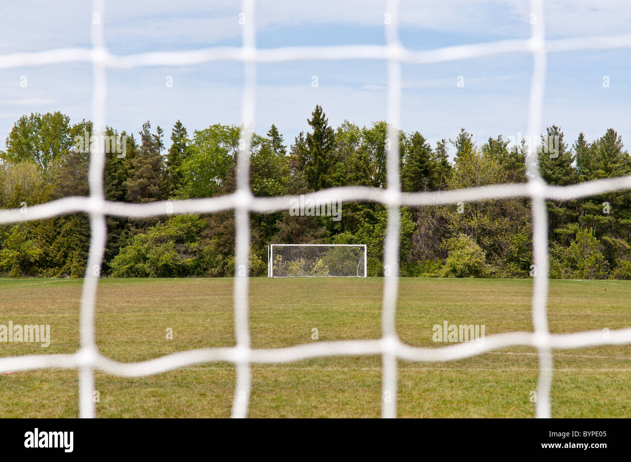 An outdoor soccer field viewed through the mesh of one of the nets ...
