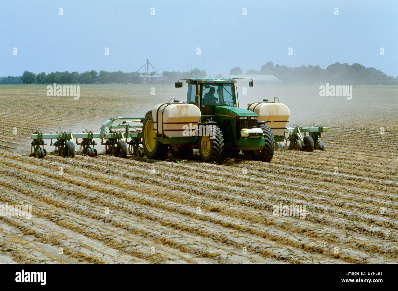 A tractor & 12-row implement cultivates middles & bands Roundup Ultra ...