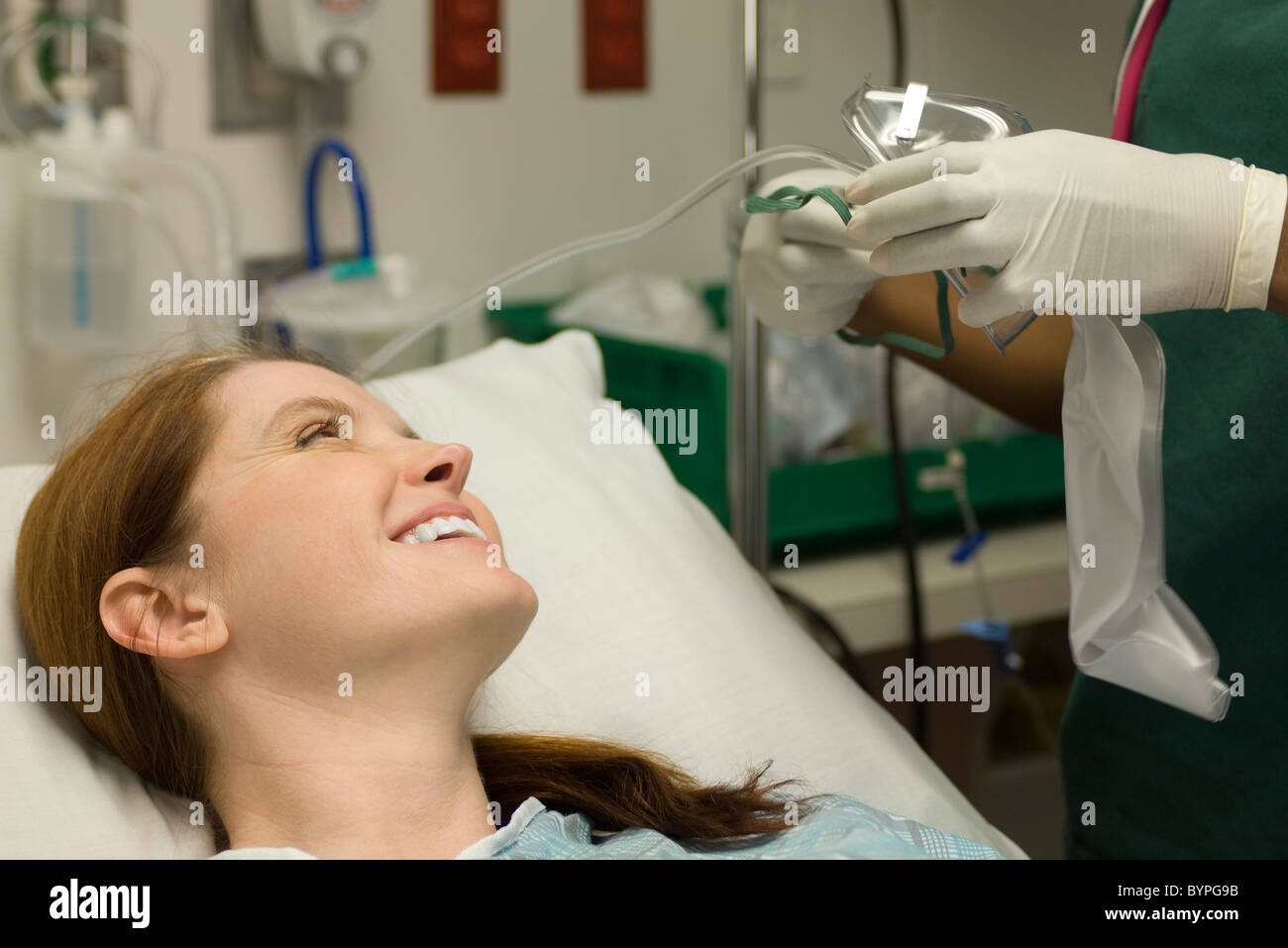 Female patient smiling as nurse prepares oxygen mask Stock Photo - Alamy