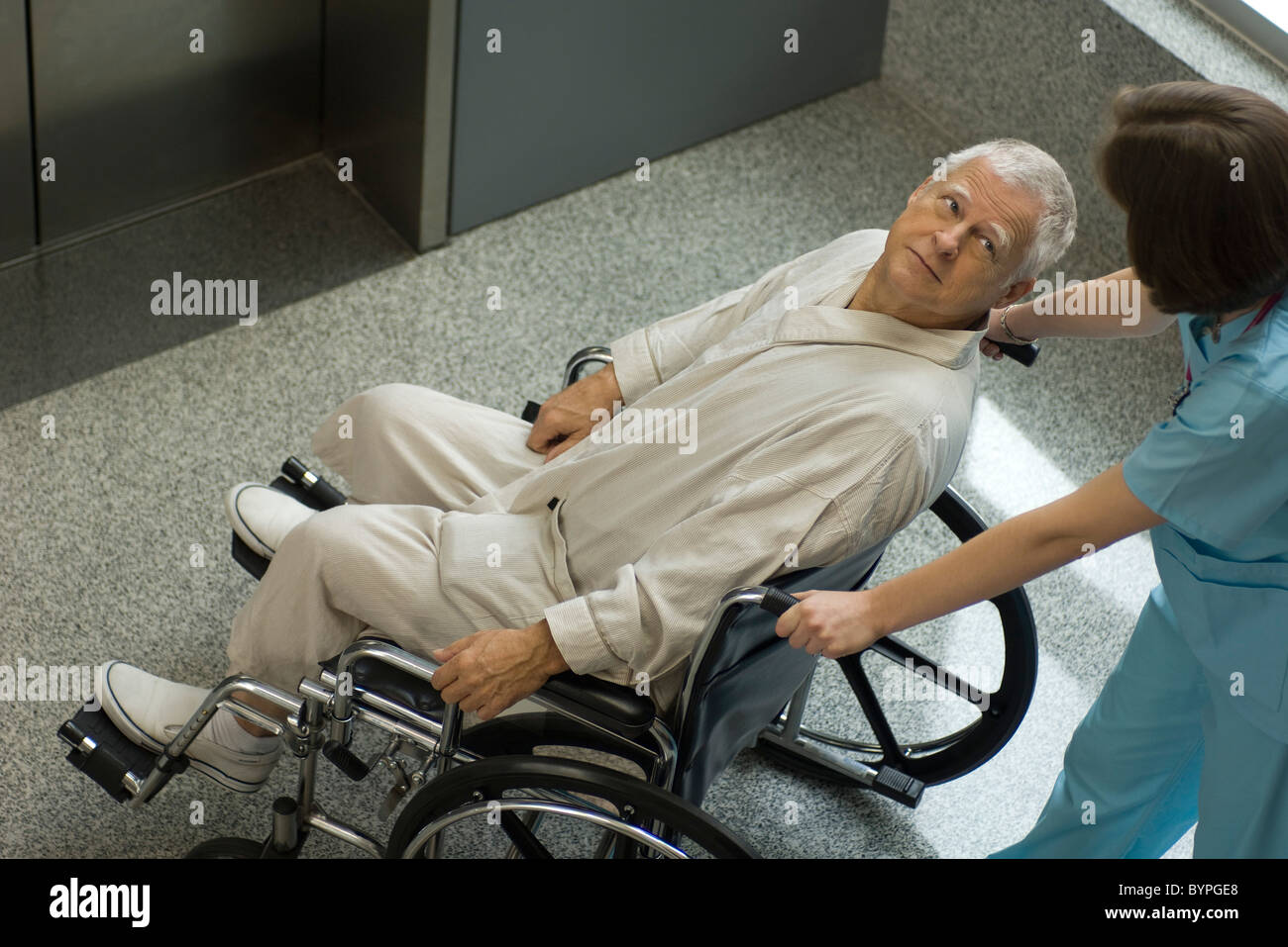 Nurse pushing senior patient in wheelchair Stock Photo - Alamy