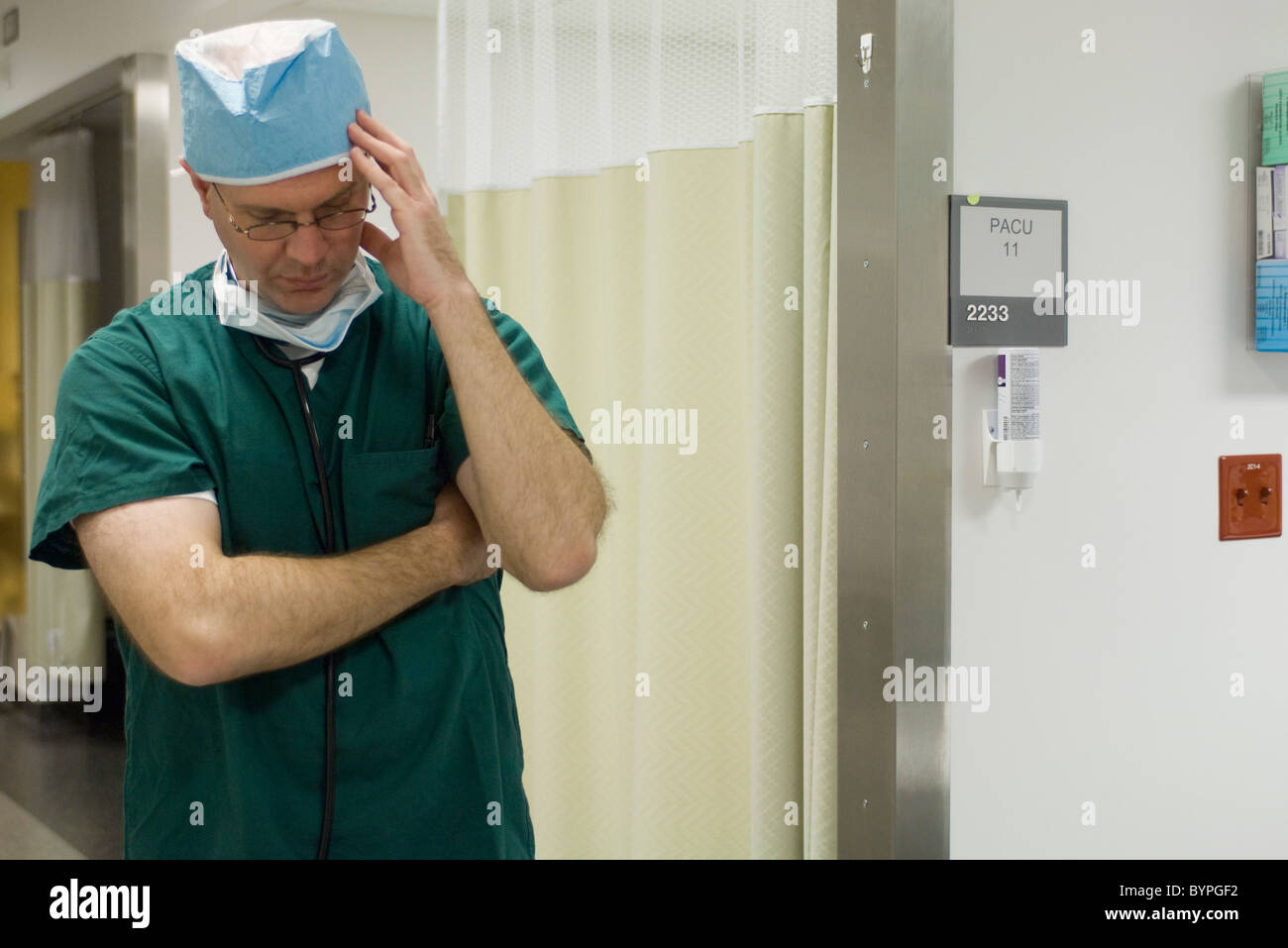 Doctor holding head and looking down Stock Photo - Alamy