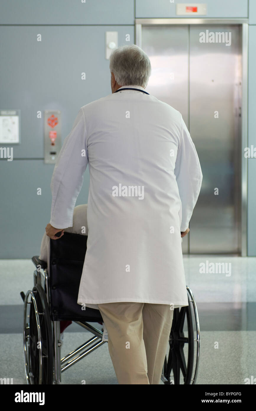 Doctor pushing patient in wheelchair Stock Photo - Alamy