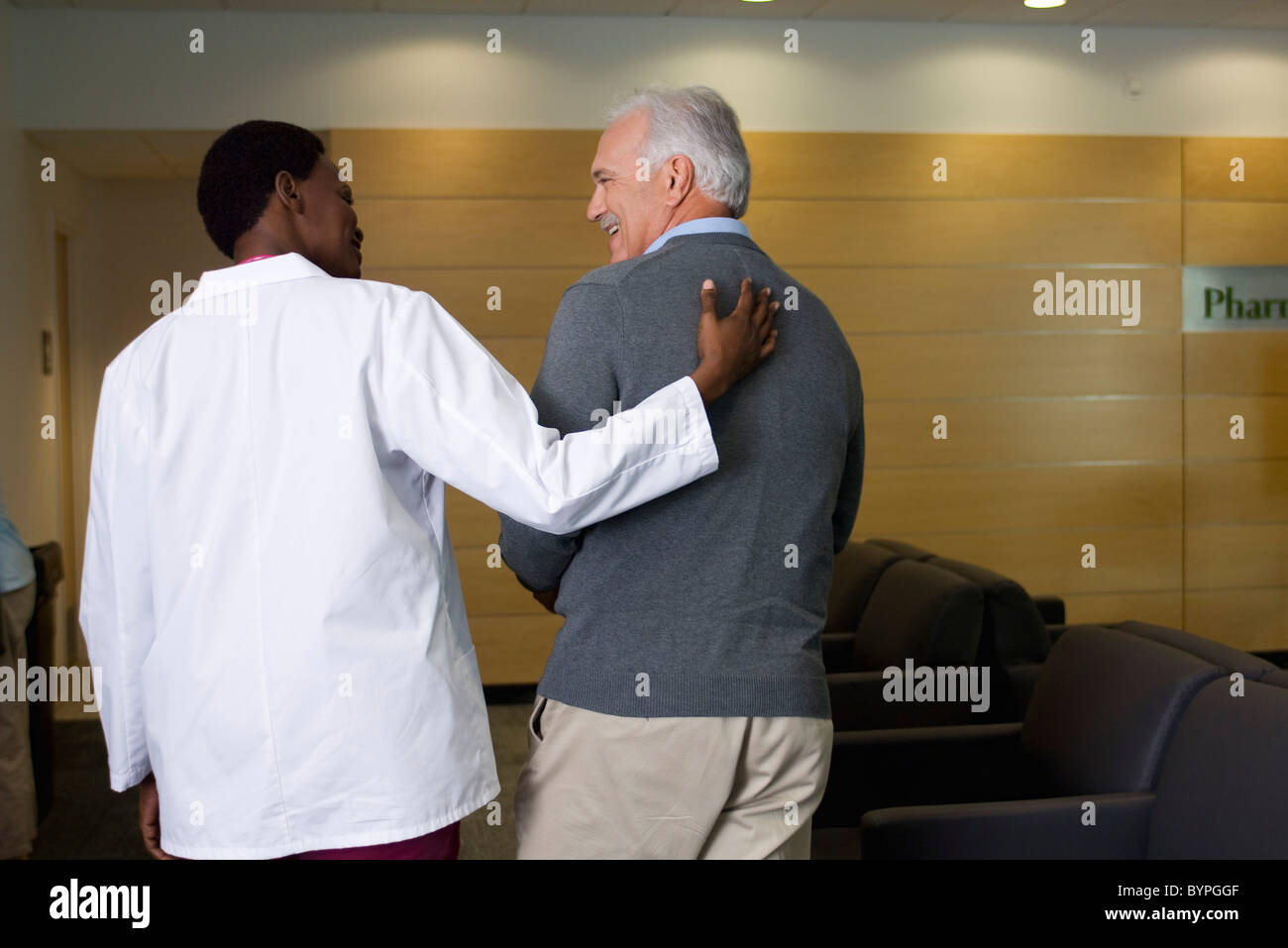 Doctor walking and talking with patient Stock Photo - Alamy