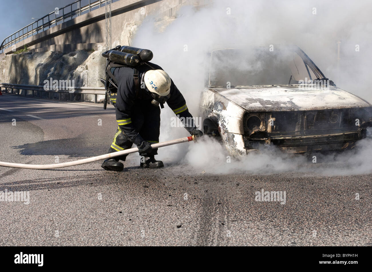 Firefighter extinguishes a burning car Stock Photo - Alamy