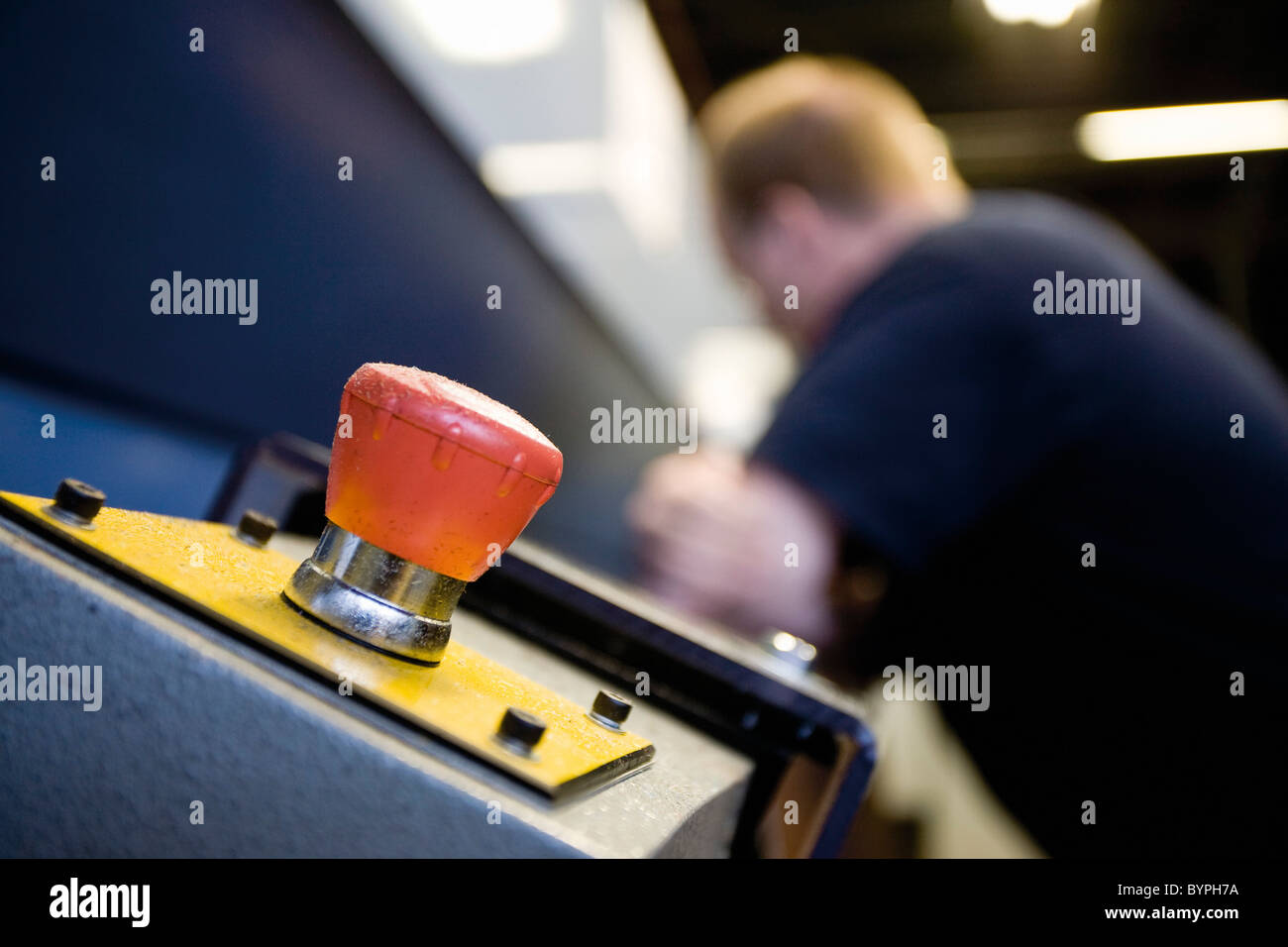 Emergency stop knob on machine in carpet tile factory Stock Photo - Alamy