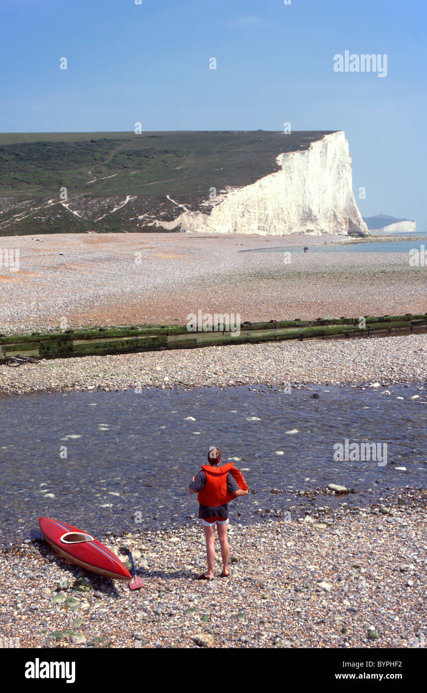 Canoeist preparing canoe beside Cuckmere river estuary Seven Sisters ...