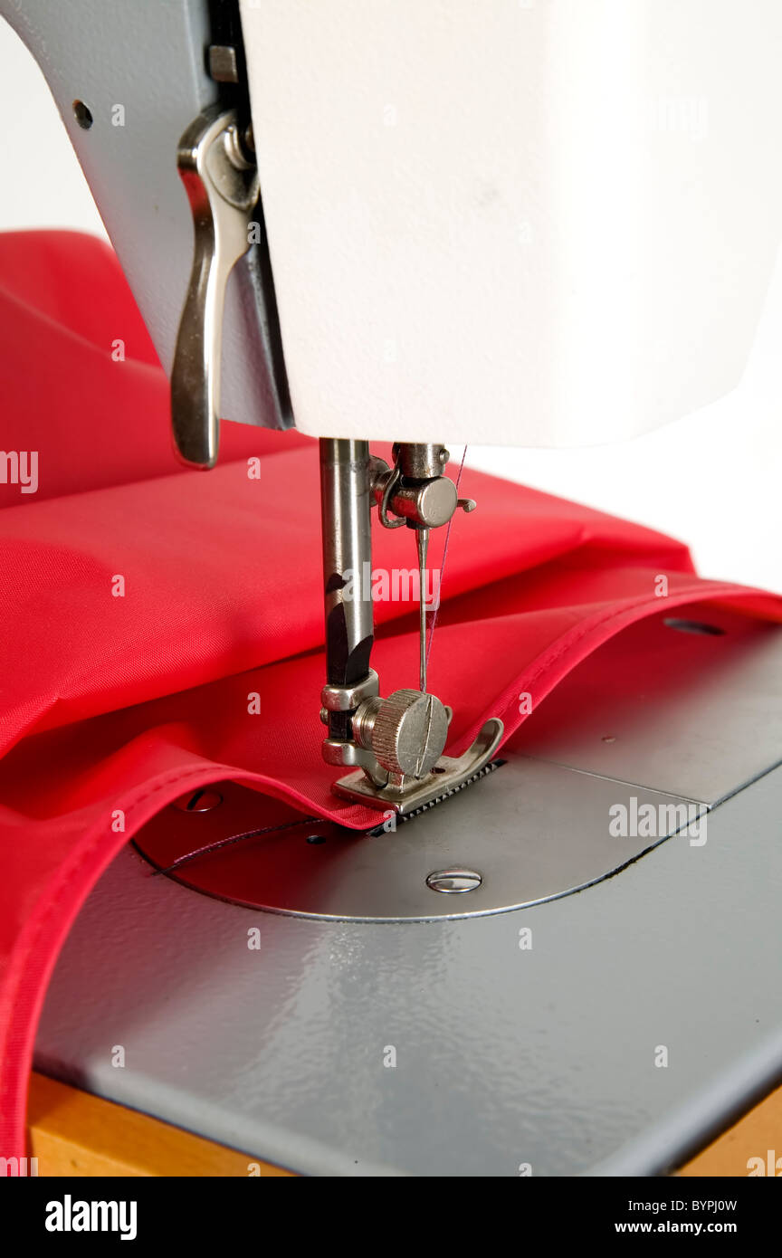 Sewing machine is stitching piece of red fabric Stock Photo - Alamy