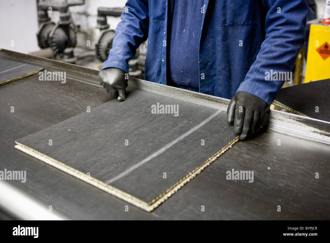 Factory worker checking quality of carpet tile Stock Photo - Alamy