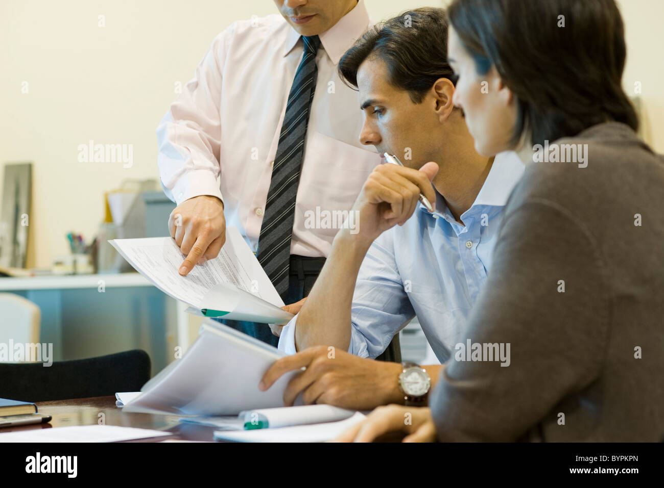 Executives looking at document together Stock Photo - Alamy