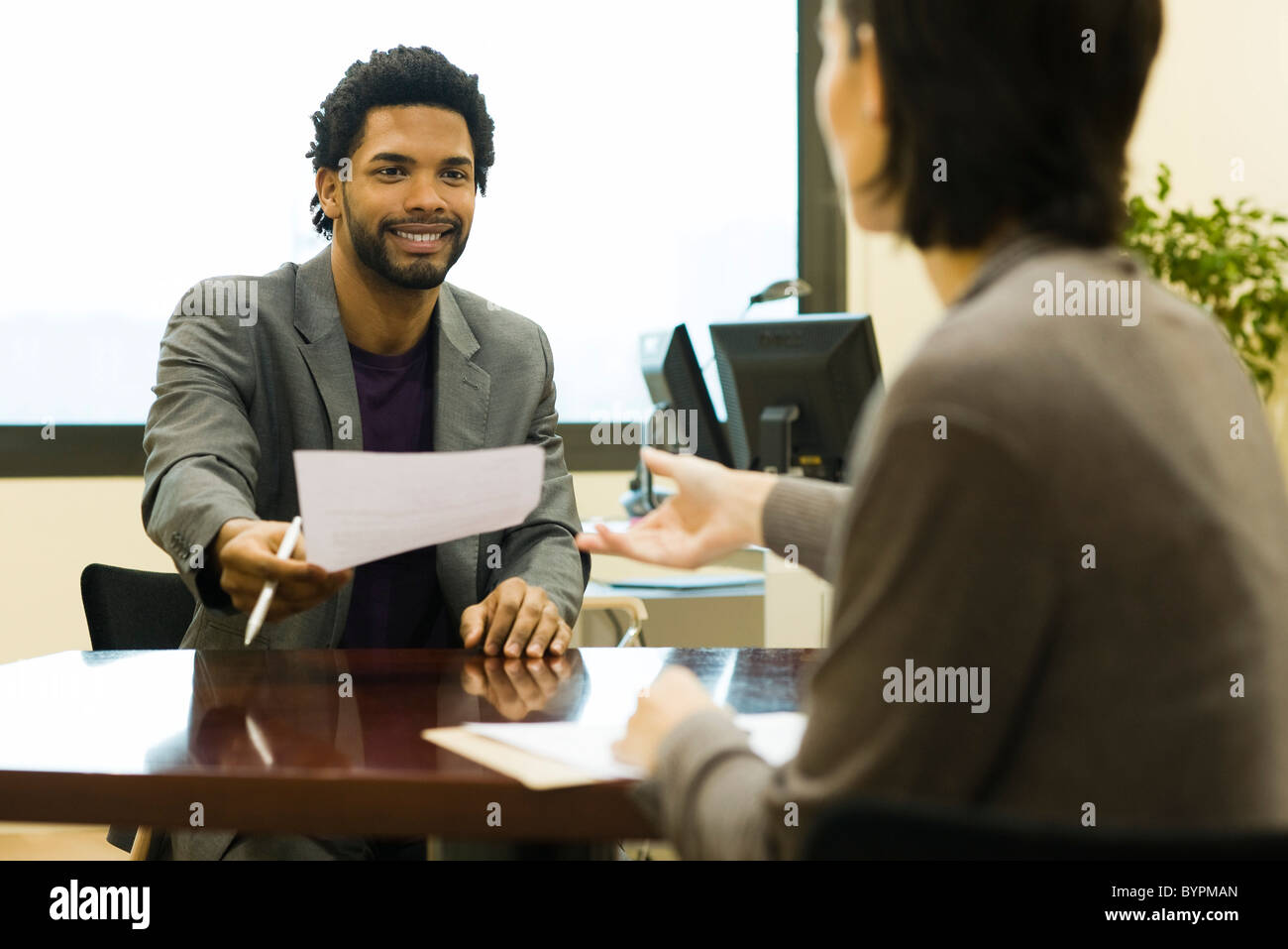 Executive handing document to colleague Stock Photo - Alamy