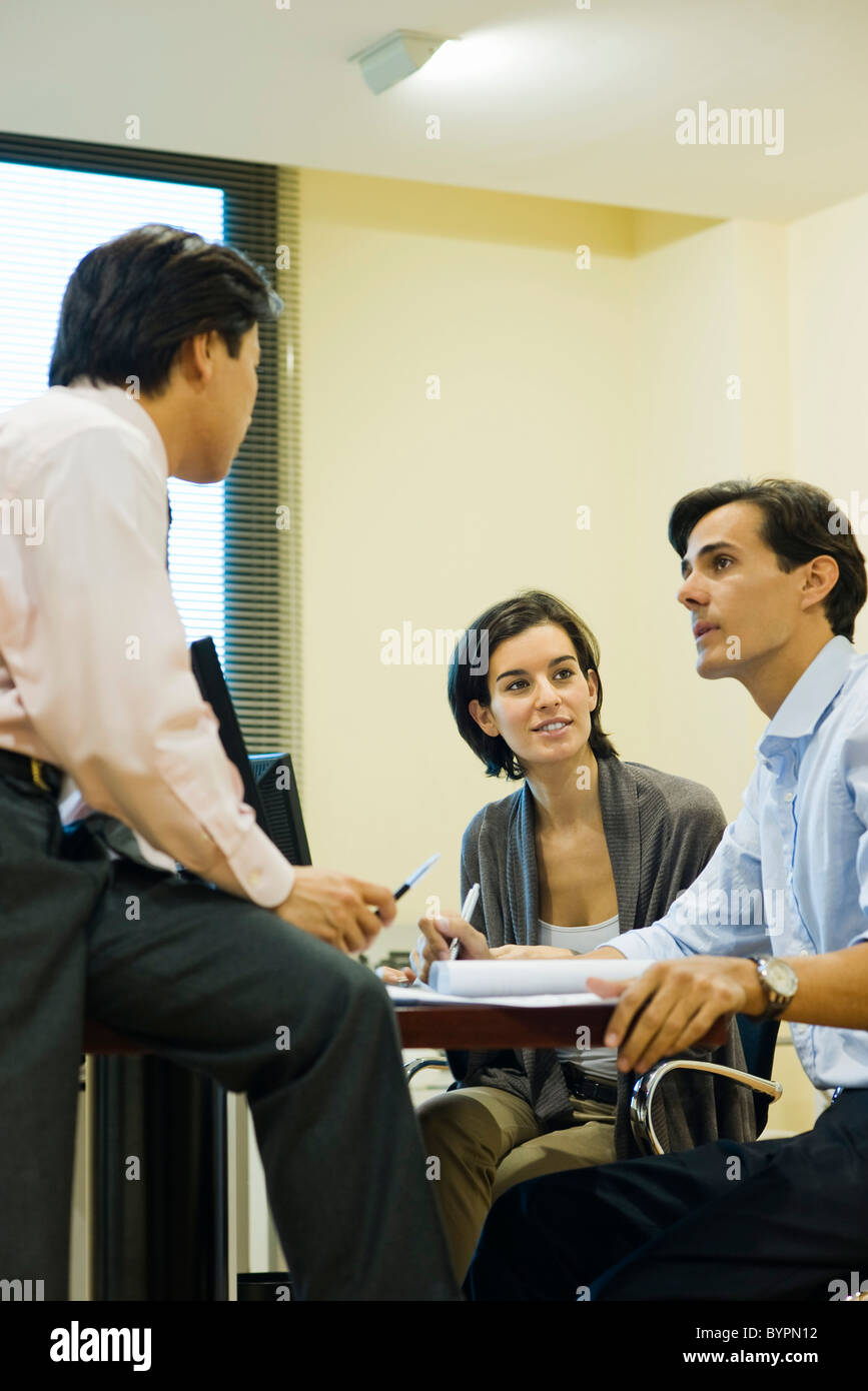 Executives talking together at desk Stock Photo - Alamy