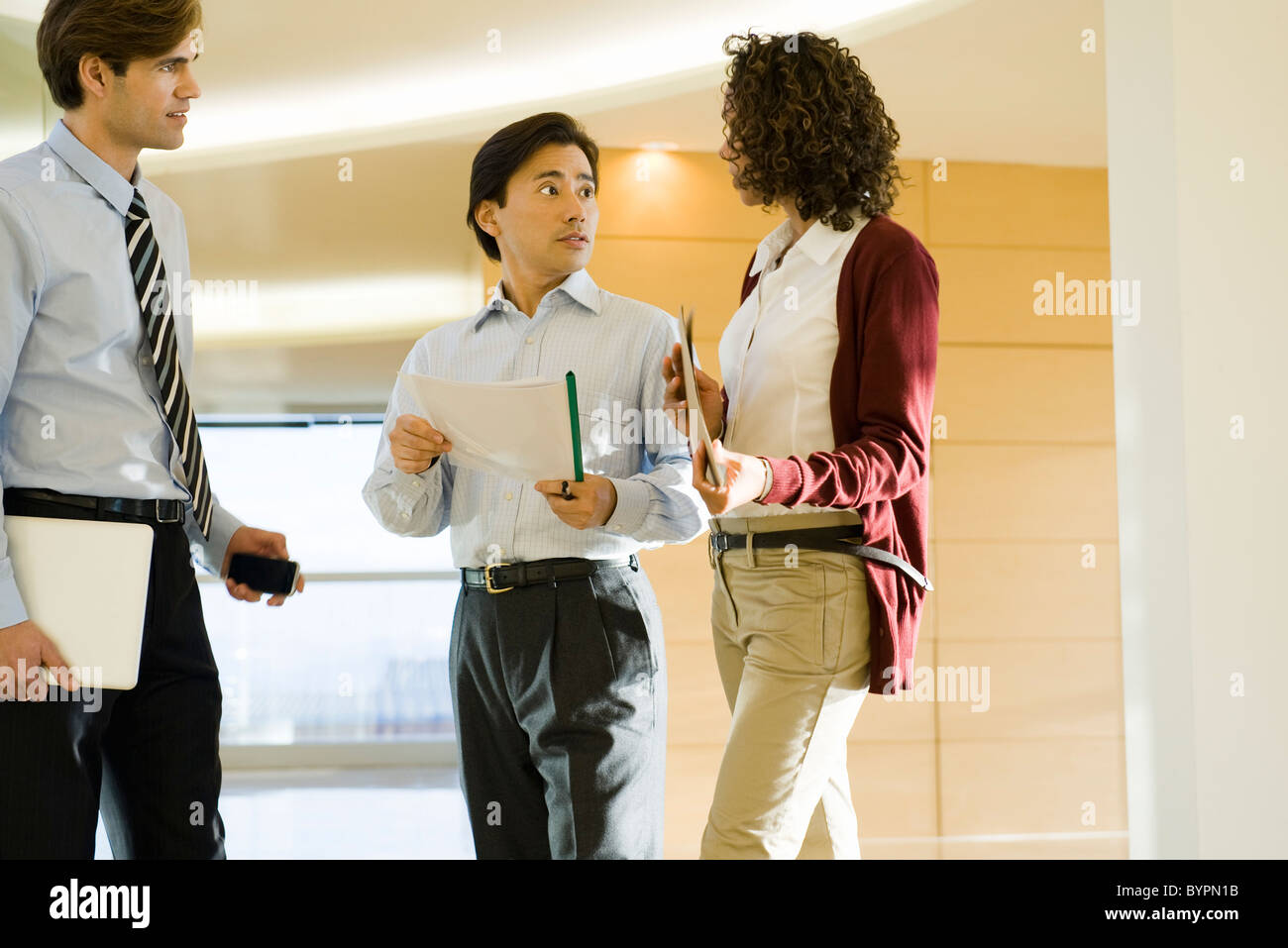 Executives talking in corridor Stock Photo - Alamy