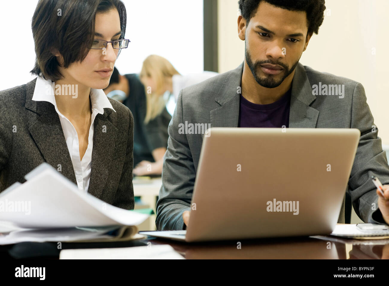 Executives working together on laptop computer Stock Photo - Alamy