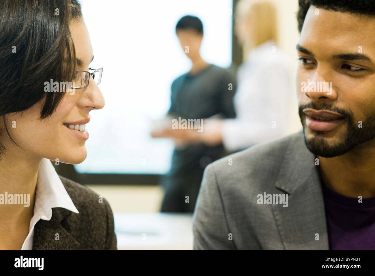 Male and female colleagues talking together Stock Photo - Alamy