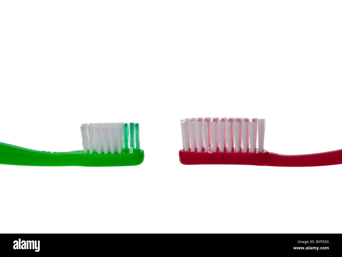 a green child's or ladies and red adult's toothbrush isolated against a ...