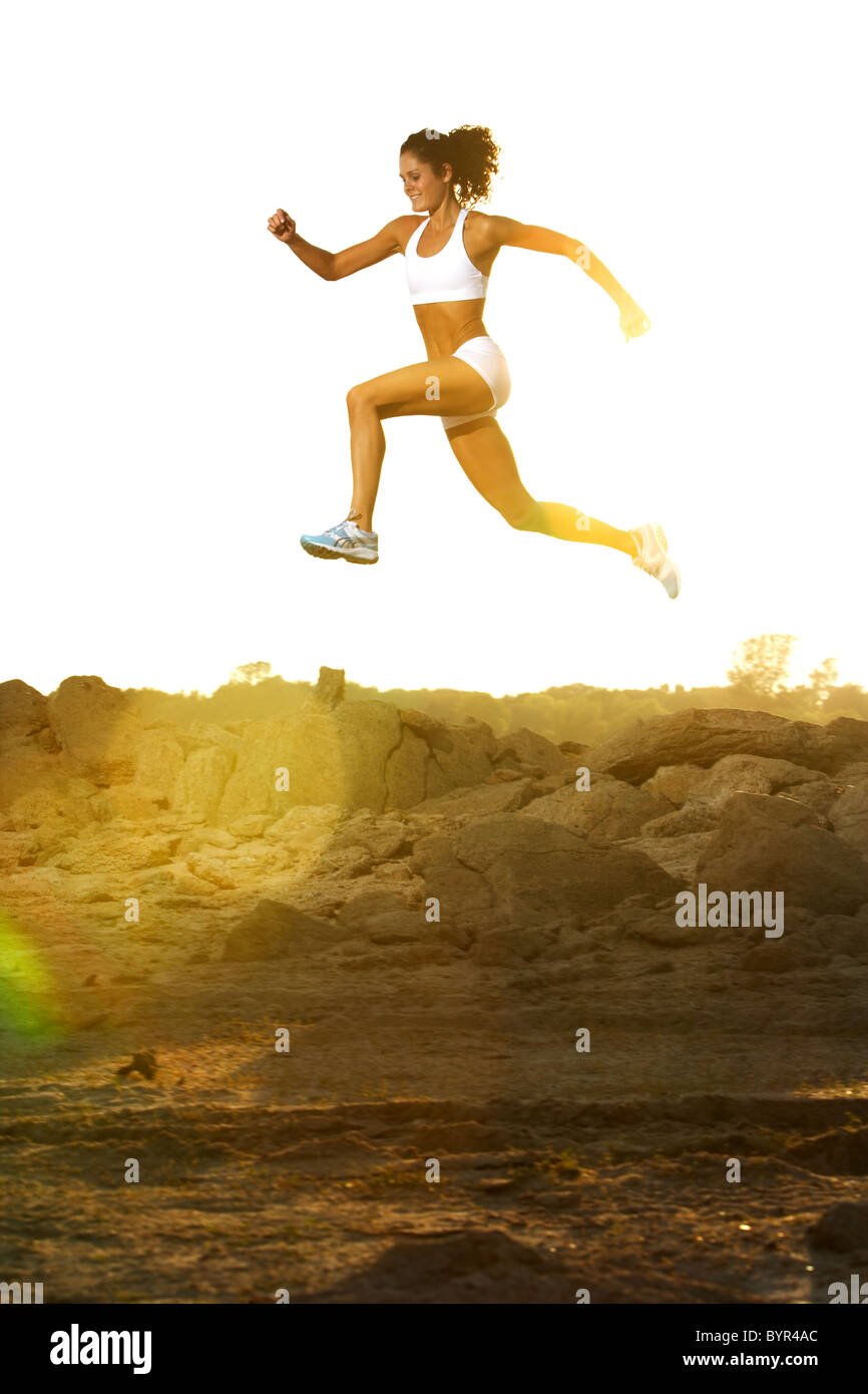 A Woman Running and Jumping Over Rocks on a Mountain Stock Photo - Alamy