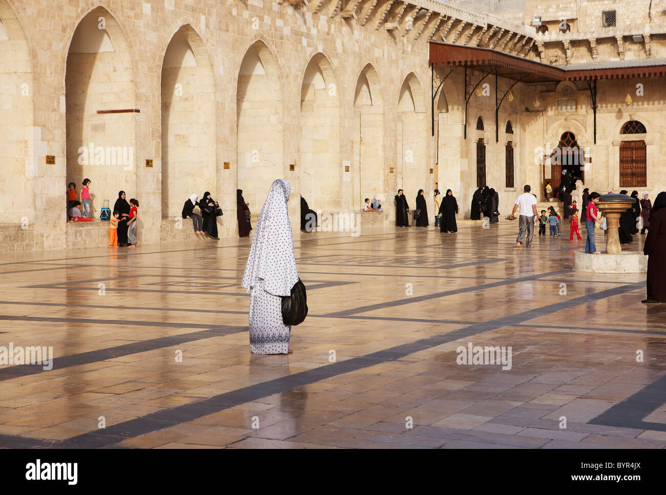 Female tourist standing in visitor's robe in the courtyard of the Great ...
