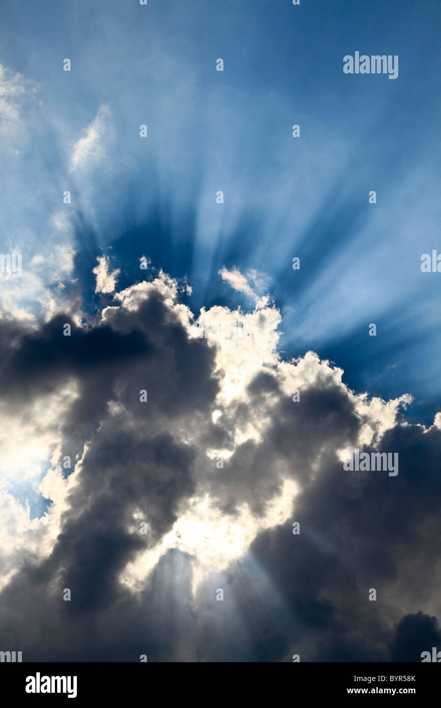 Sun rays emerging from behind a cumulus cloud on a bright summers day Stock Photo - Alamy