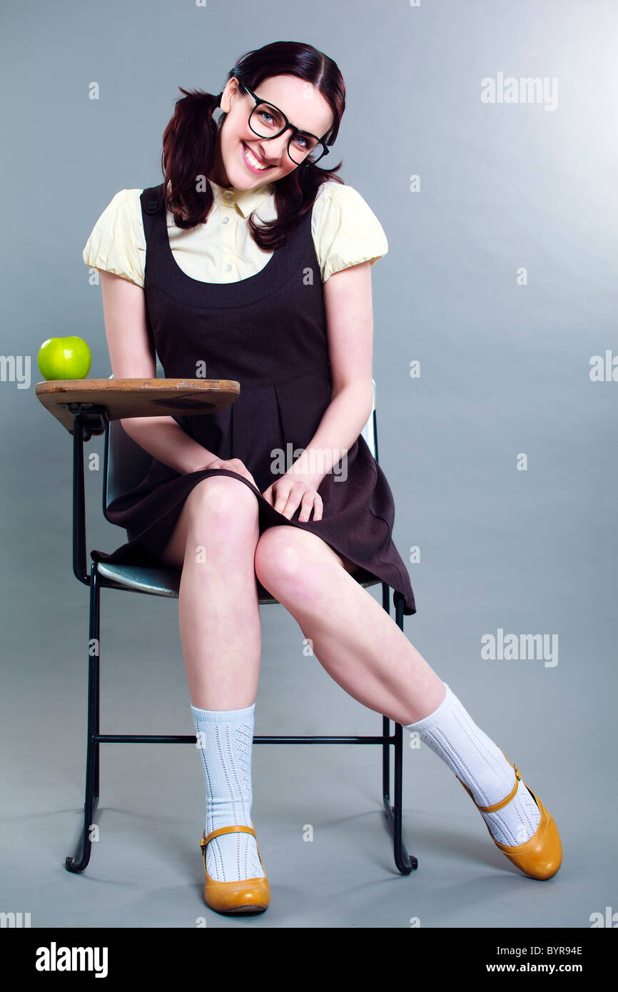 coy geeky school girl full length smiling at her desk Stock Photo - Alamy
