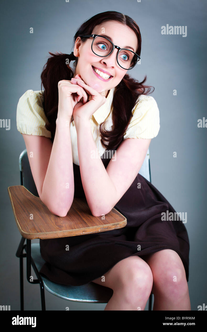 geeky school girl intensely smiling at desk Stock Photo - Alamy
