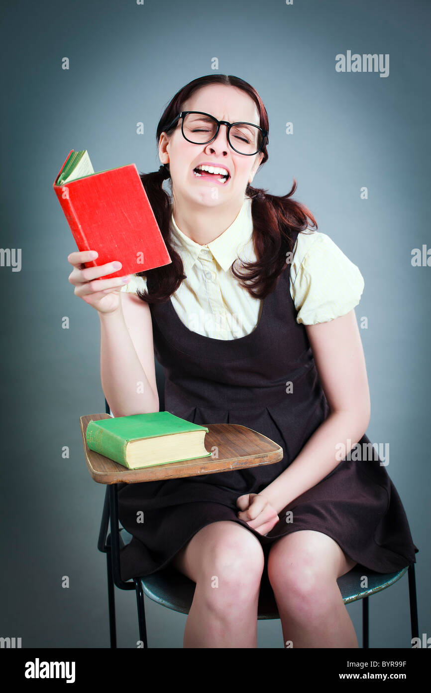 geeky school girl dramatically crying whilst reading at desk Stock ...