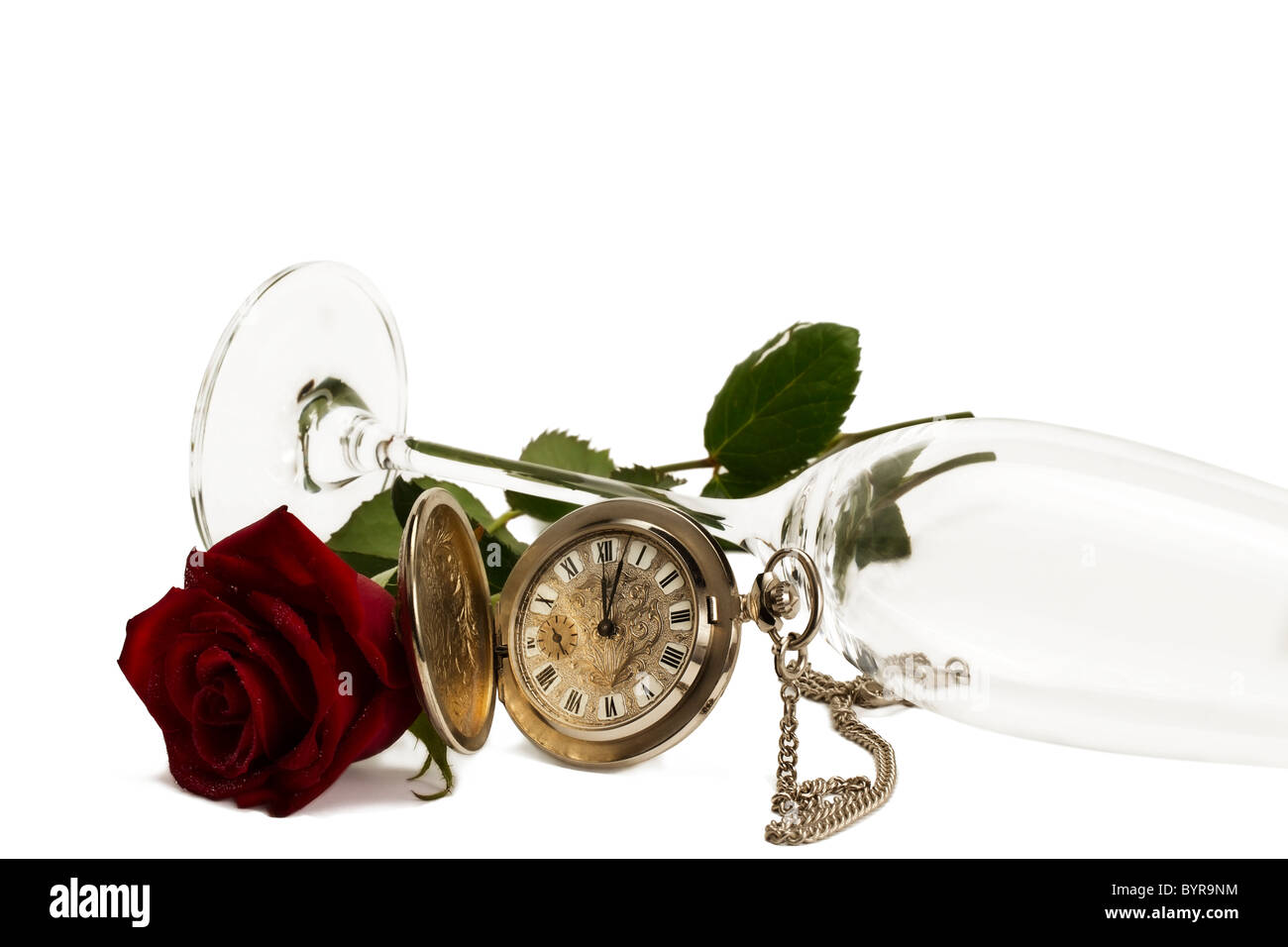 old pocket watch with a red wet rose under a lying champagne glass on ...