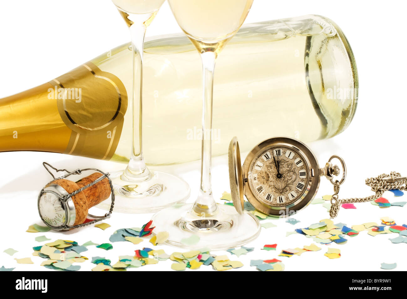 two glasses with champagne, old pocket watch, cork and confetti in ...