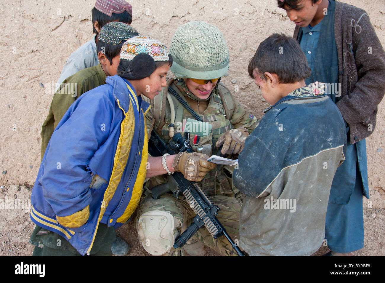 Soldier with children in Helmand Afghanistan Stock Photo - Alamy