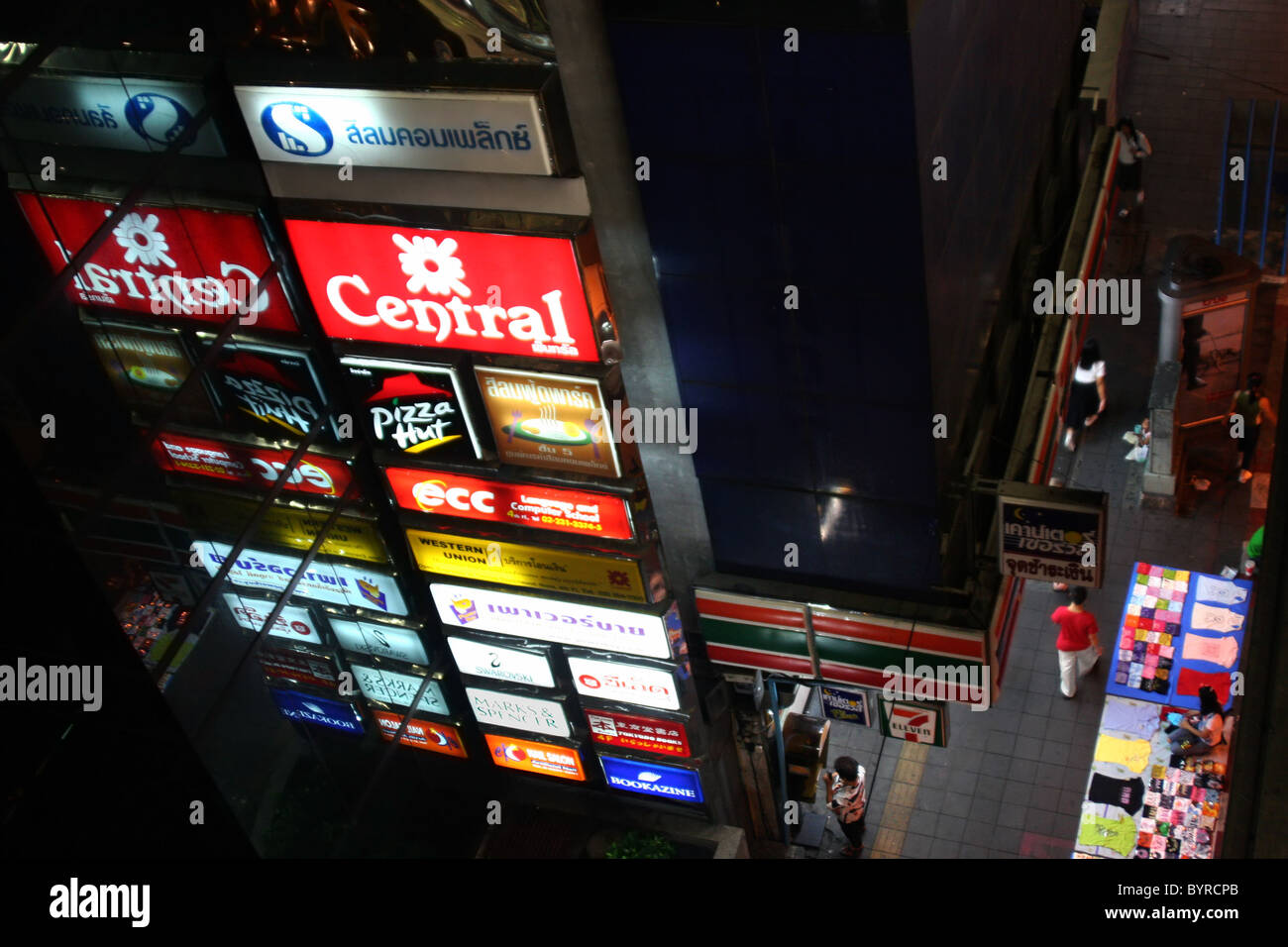 A tall sign advertising many types of businesses is reflecting off the ...